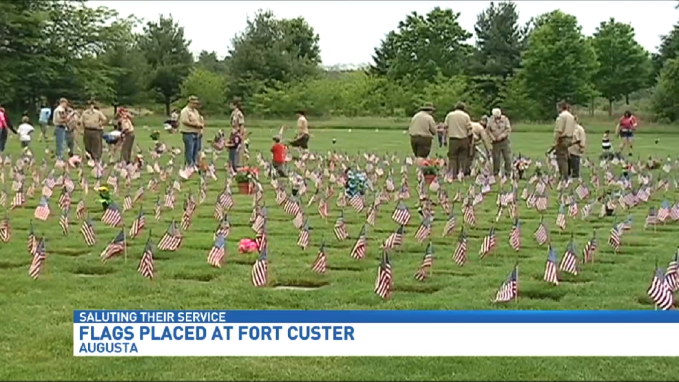Volunteers place flags on graves at Ft. Custer National Cemetery | WWMT